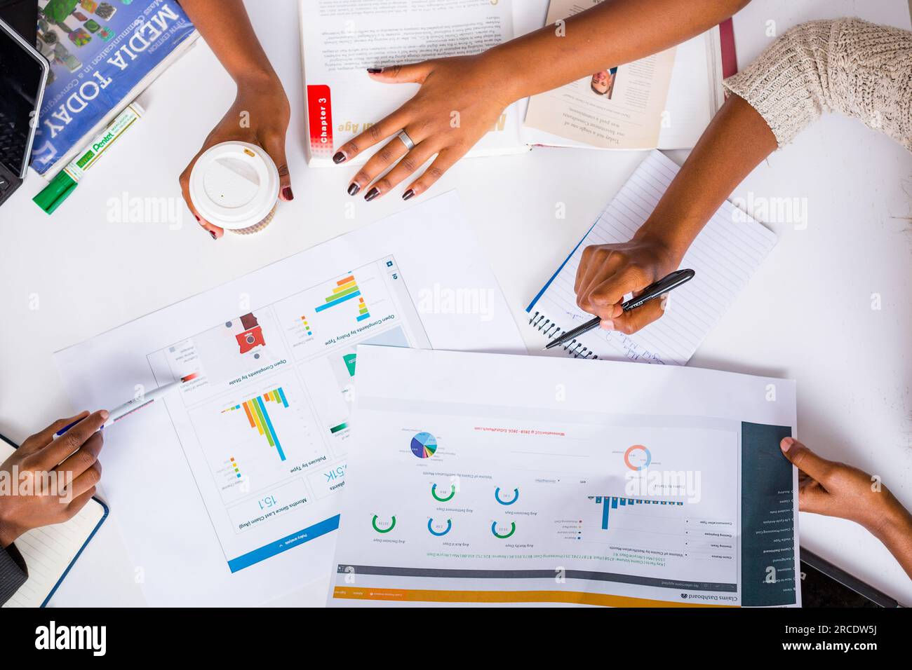 Hands touching illustrations chart pies flat lay on table round table ...