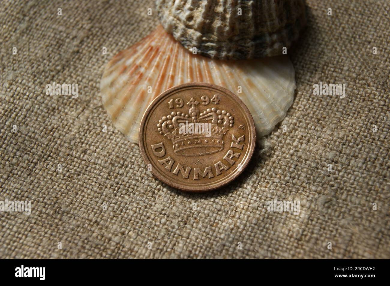 Danish coin and shells on natural linen fabric. Coin with crown Stock ...
