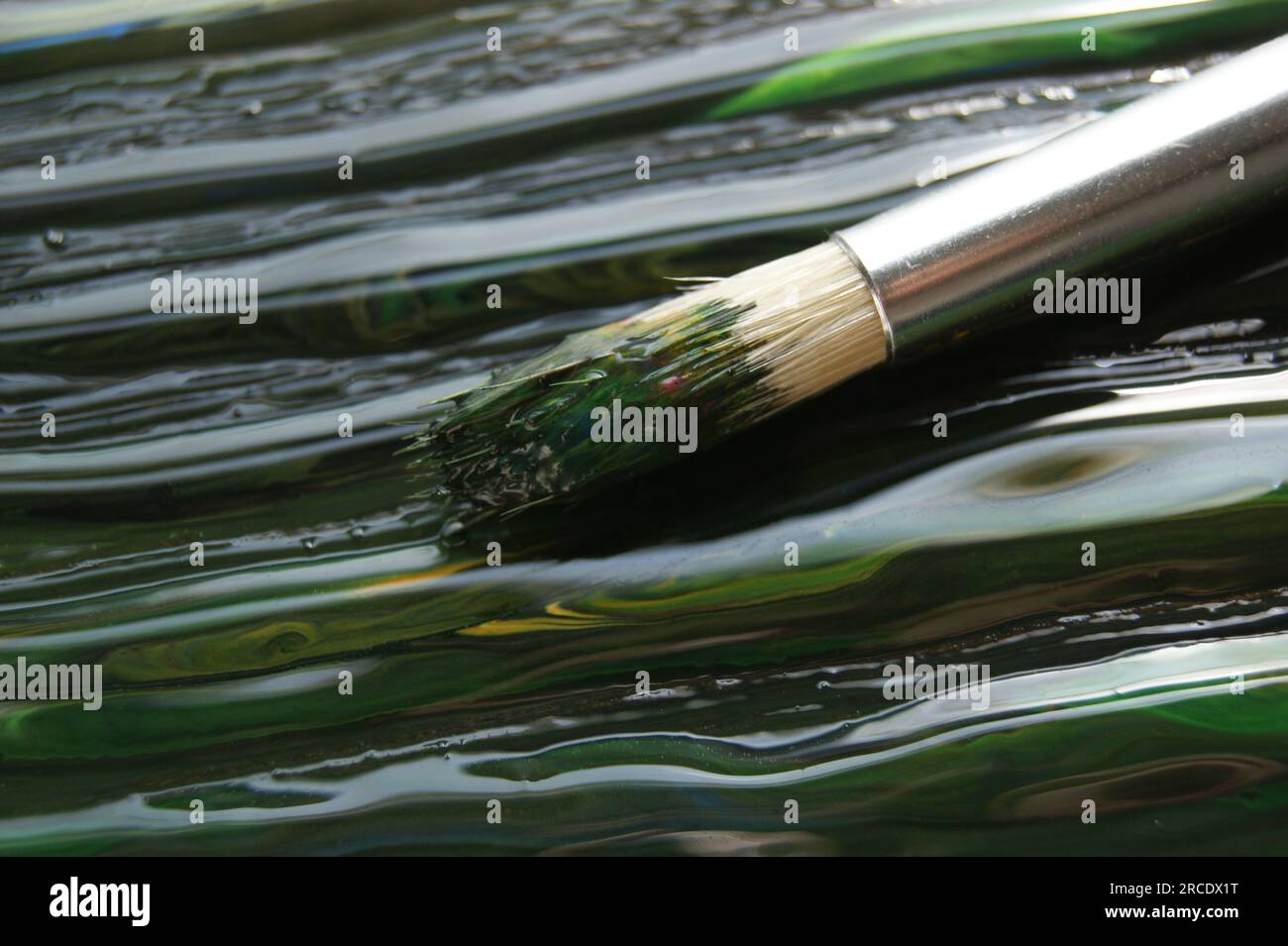 Brush on mixed wet paint. Mixture of acrylic paints Stock Photo - Alamy