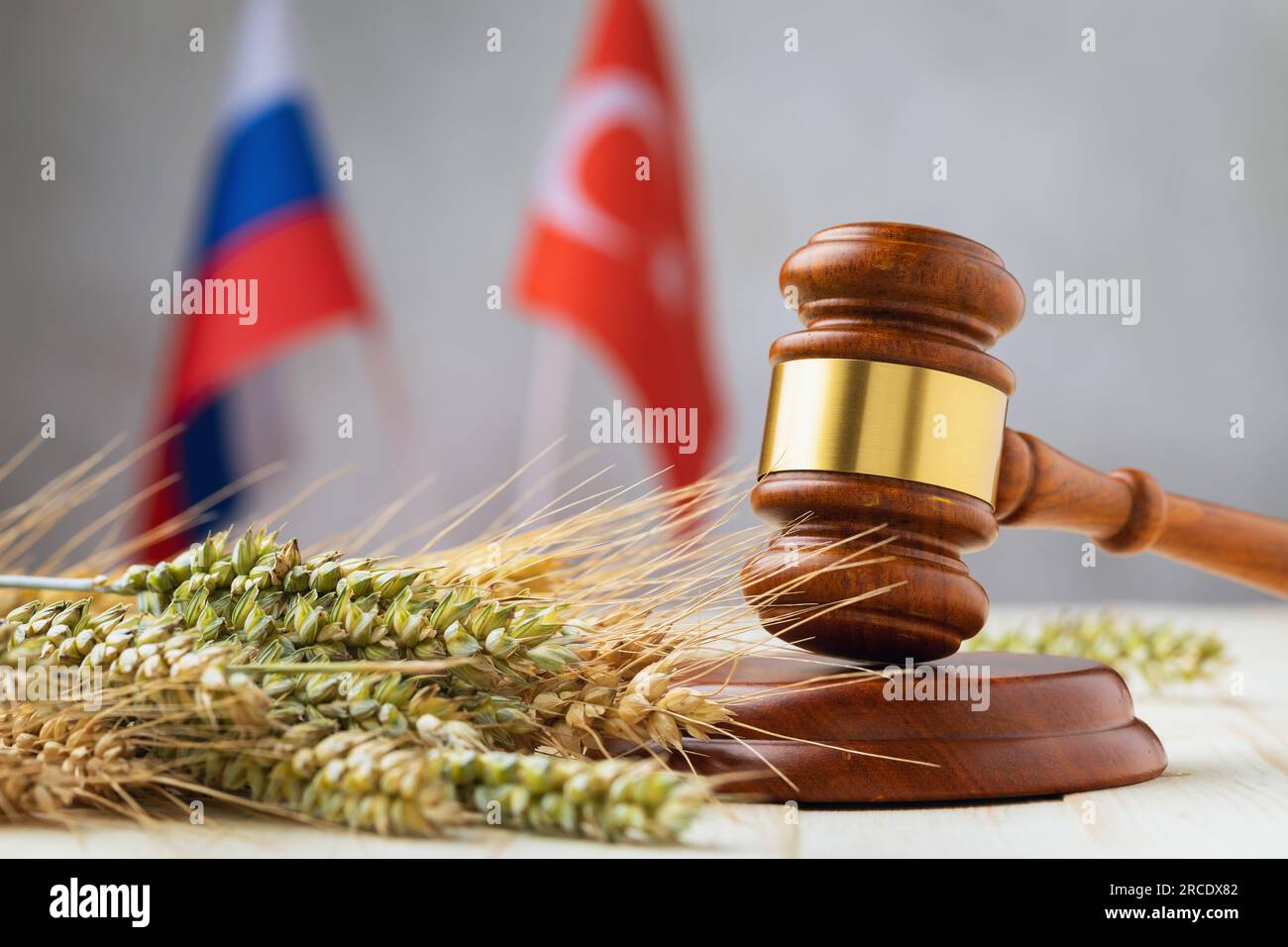 Hammer, grain ears and flags of countries on an abstract background, a ...