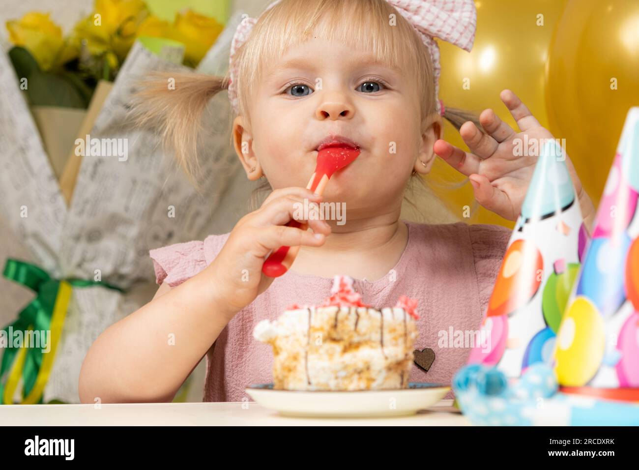 Two-year-old blonde girl eating birthday cake on her birthday Stock ...