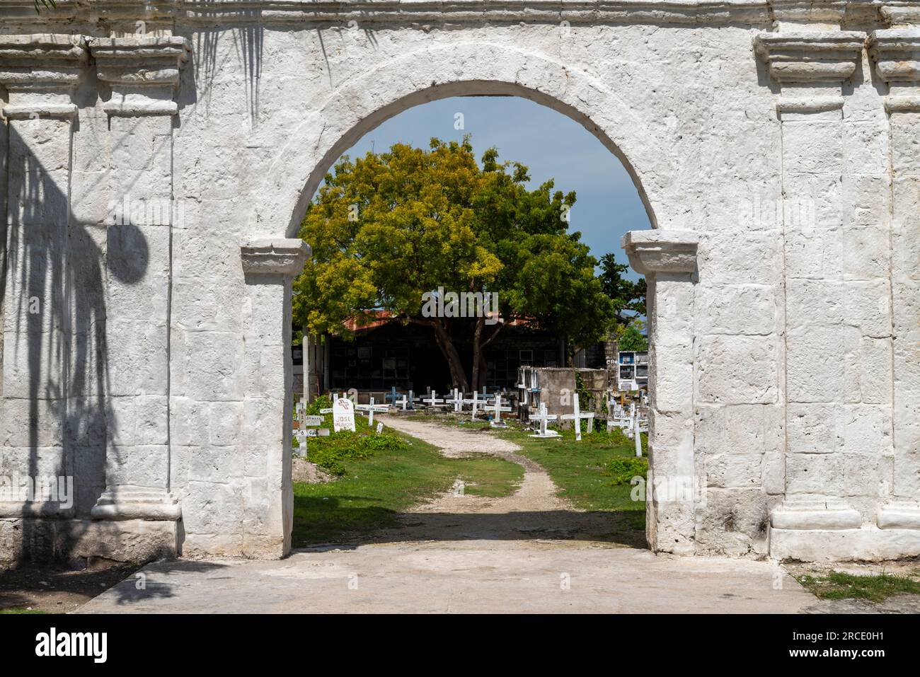 Grand arched structure,built from whitewashed stone,leading to a tree ...
