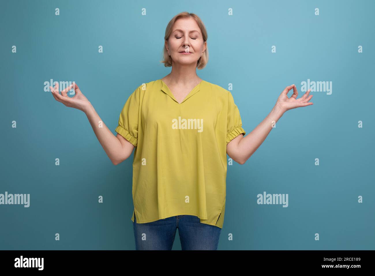 calm middle aged woman with zen feeling spread her arms to the side ...