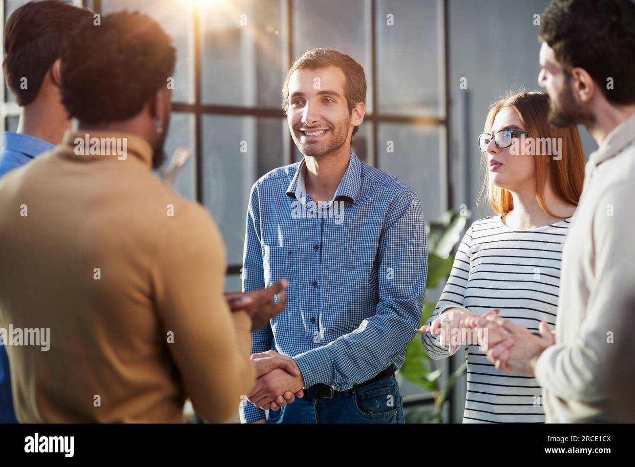 Smiling businessman standing greeting partner with handshake Stock ...