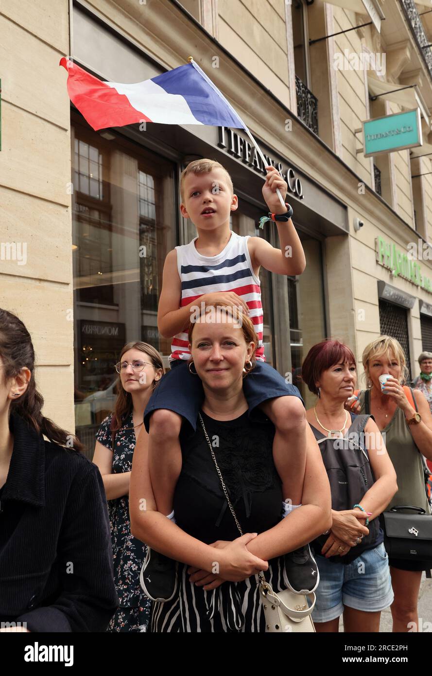 Paris, France. 14th July, 2023. A Young boy Waves the French flag as he ...