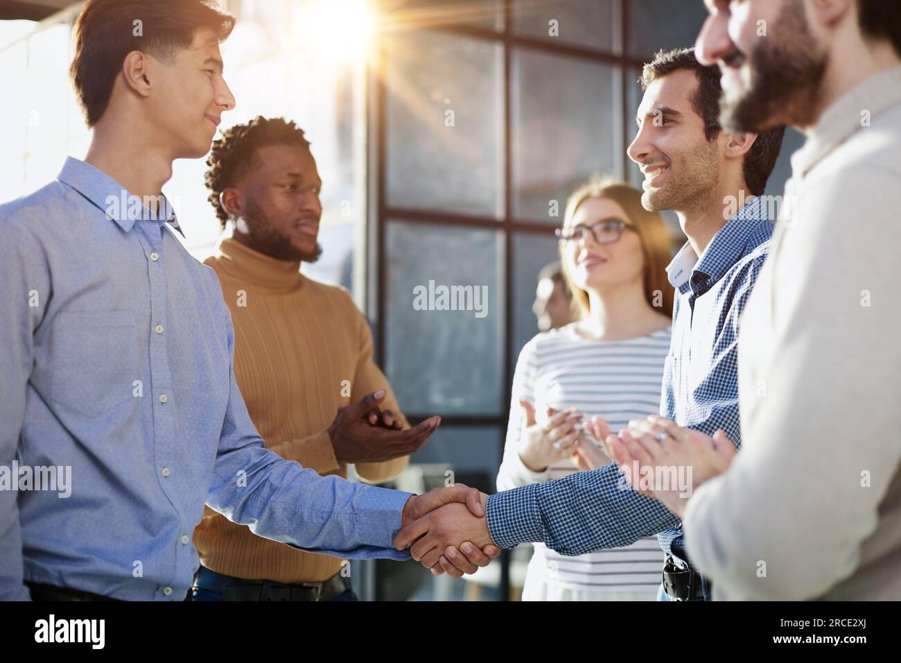 Smiling businessman standing greeting partner with handshake Stock ...