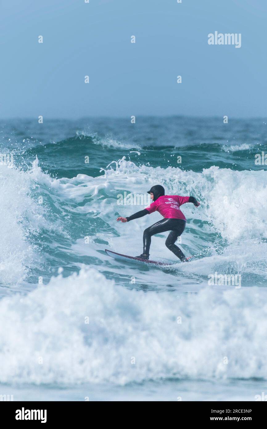 A young male surfer riding a wave during the Rip Curl Grom Search ...