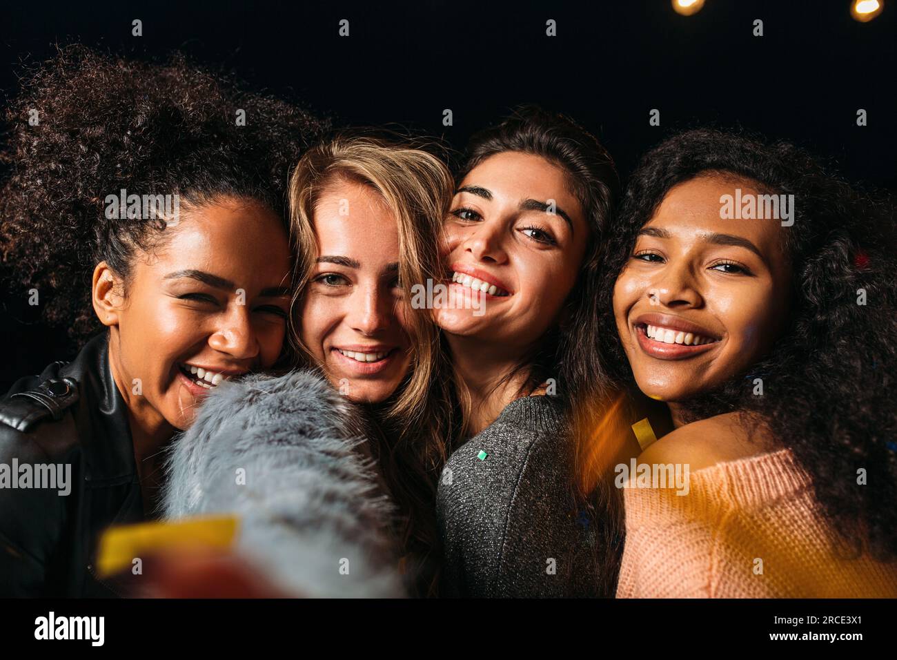 Group portrait of four happy female friends standing head to head at ...
