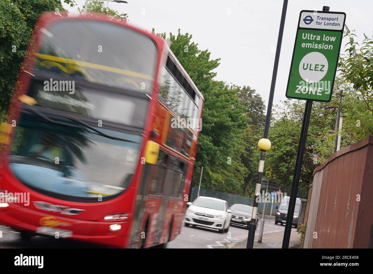 A London bus passes an information sign for the Ultra Low Emission Zone ...