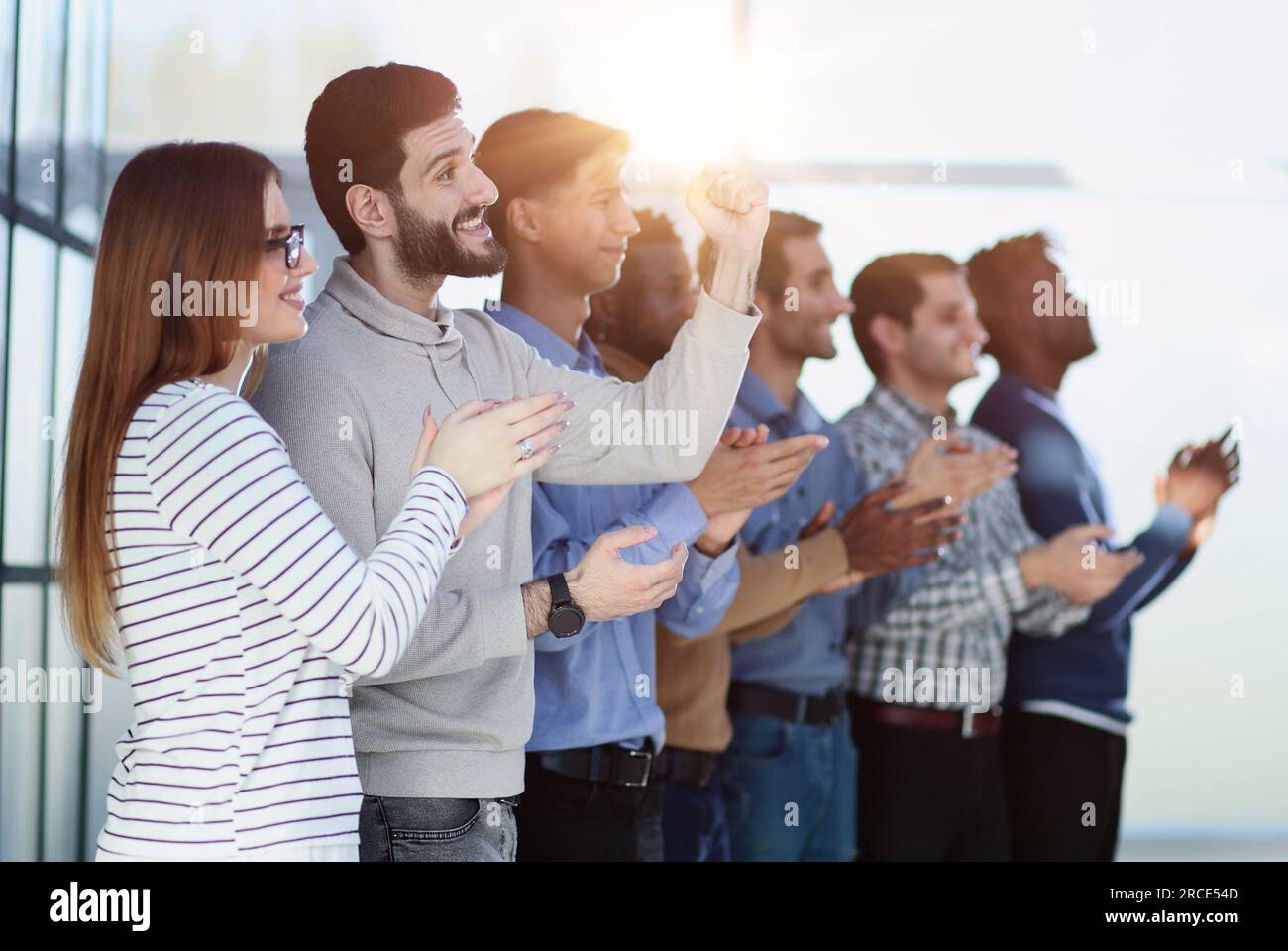 Applause. Group of cheerful young multi-ethnic people standing in a row ...