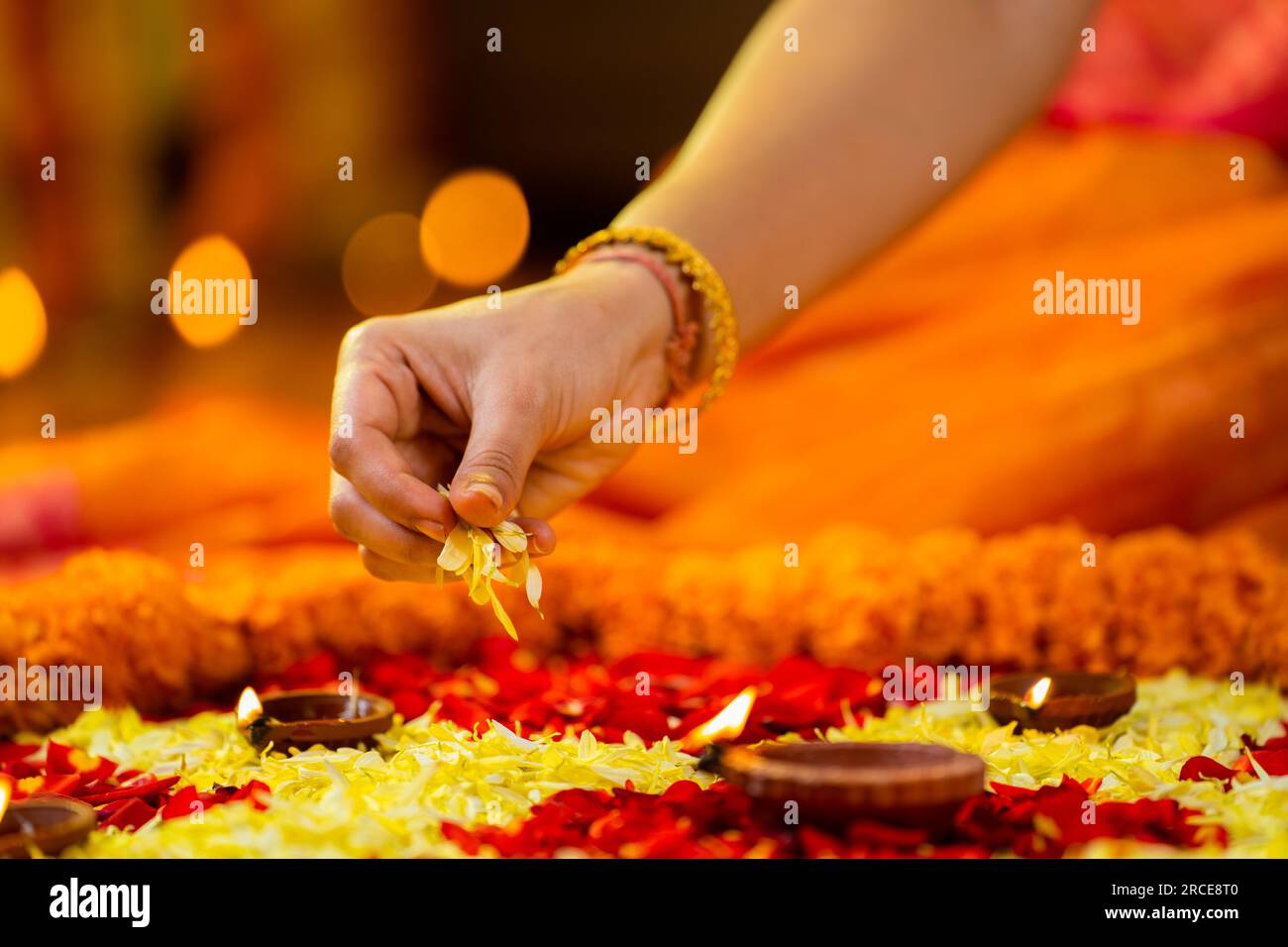 Close up shot of indian woman hands decorating Rangoli design with ...