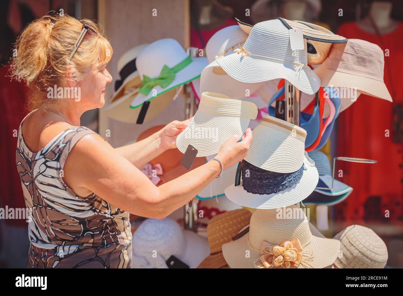 Woman choosing summer hat hi-res stock photography and images - Alamy