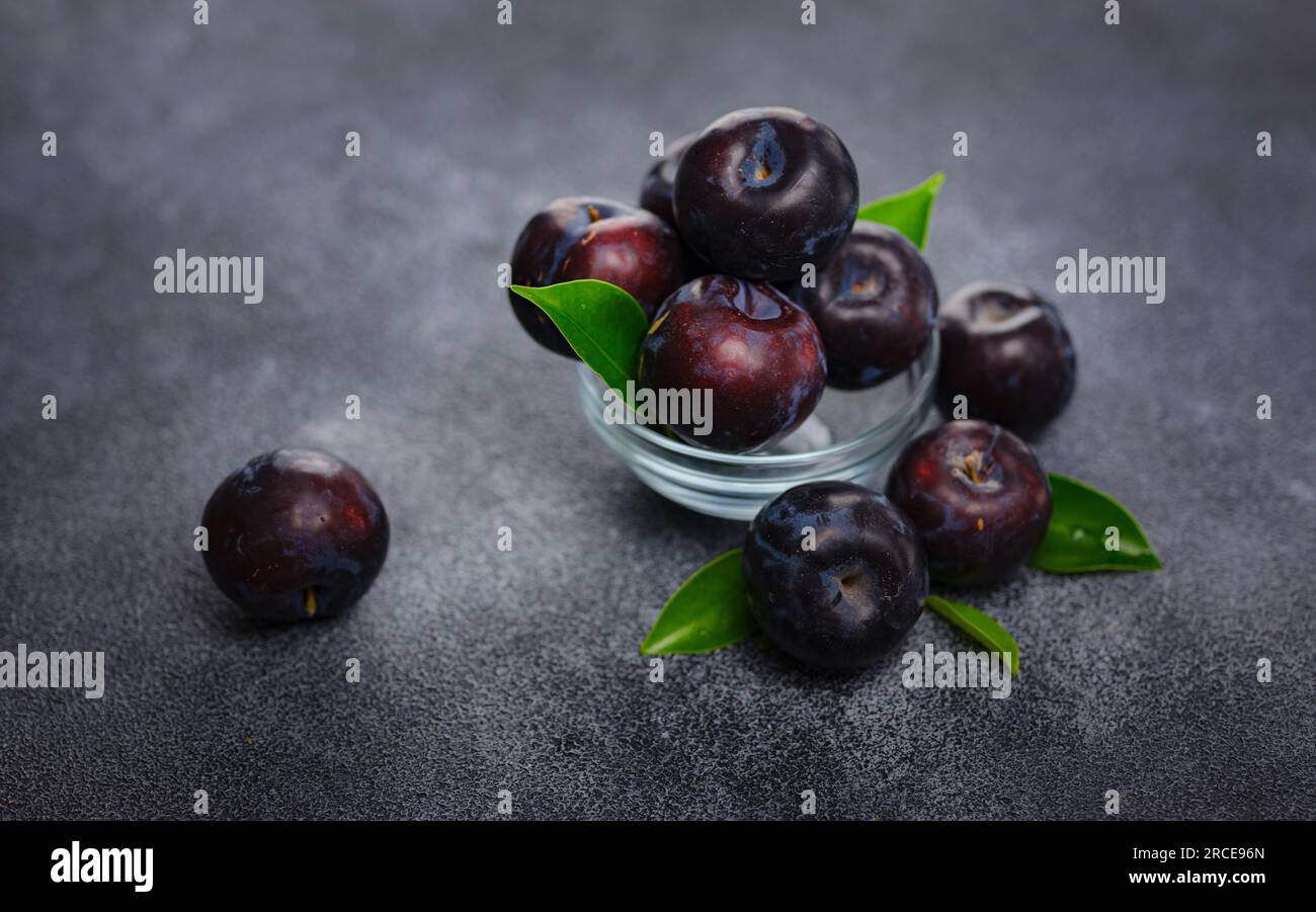 Sweet plums on dark background. Fresh blue plums with leaves. Food ...