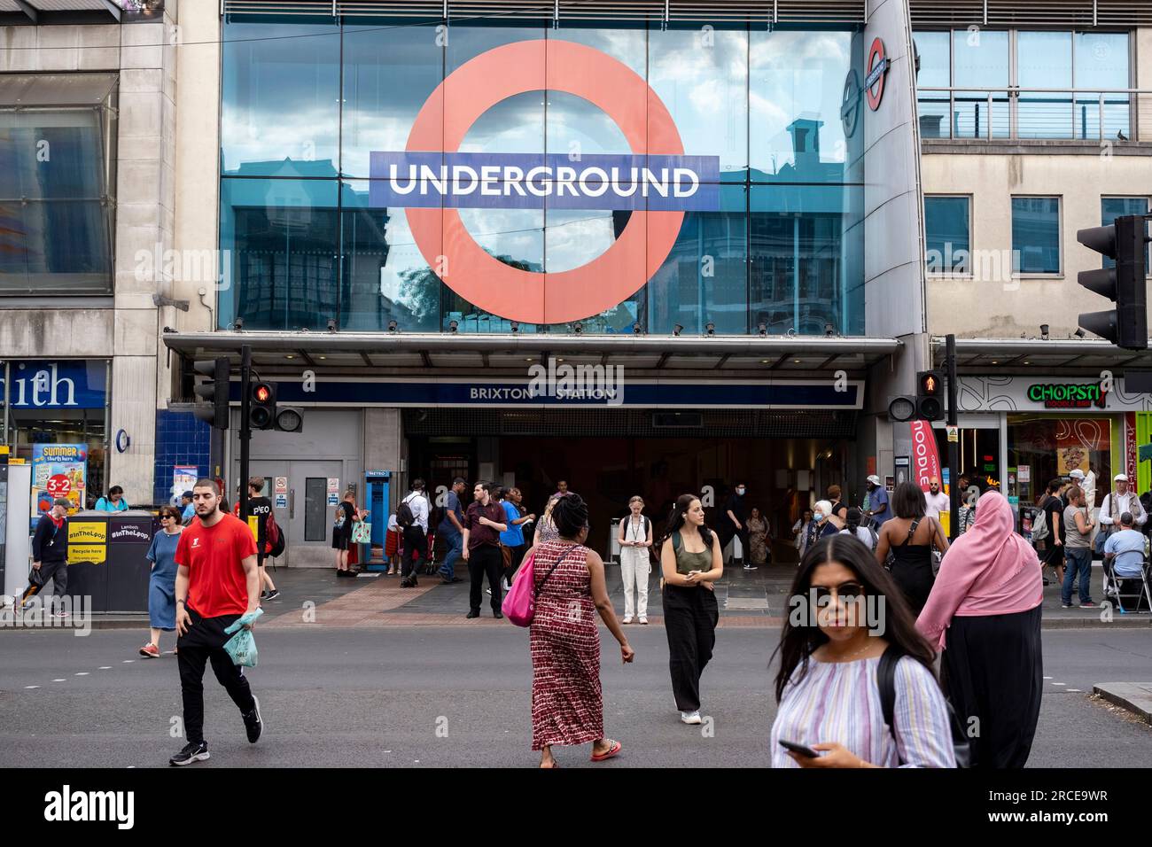 Street scene as people cross the road to and from Brixton underground ...