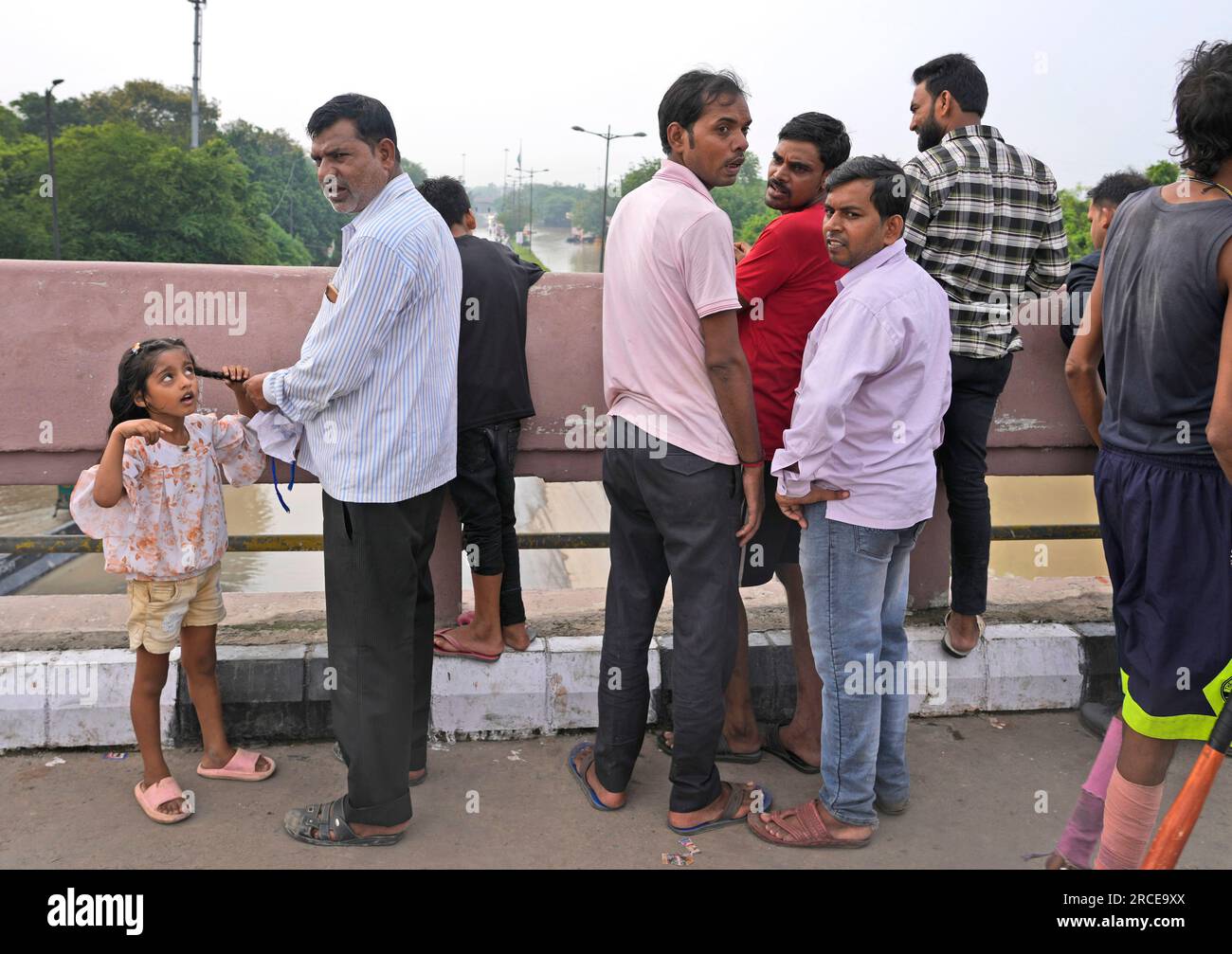 People watch flooded street from the swollen river Yamuna, from an over ...