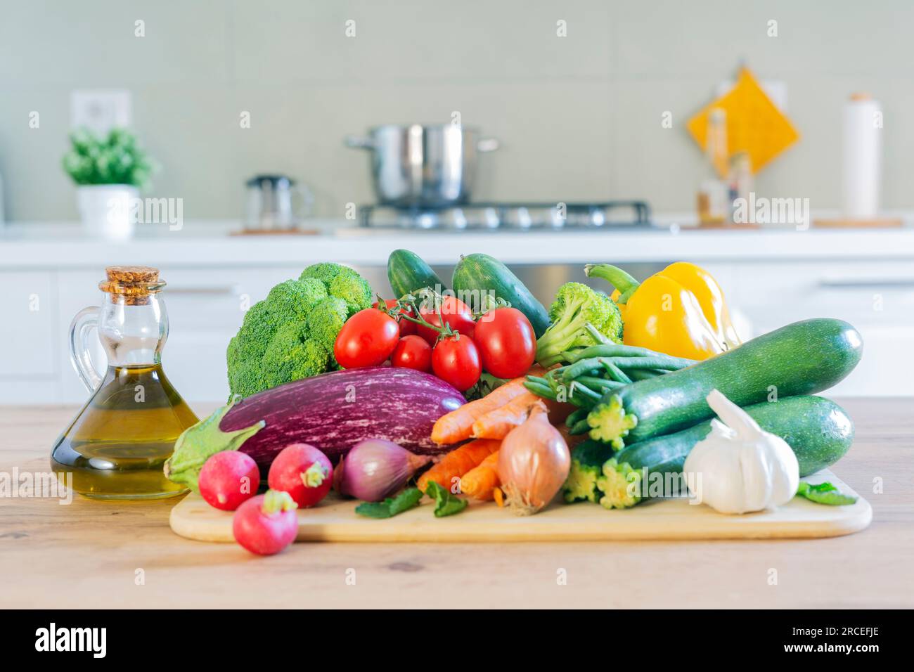 Set of fresh raw vegetables on a white wooden table in a modern kitchen ...