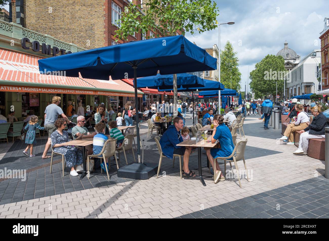 People dining al fresco at restaurant tables outside Comptoir Libanais ...
