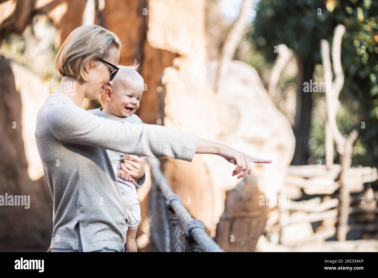 Caucasian blonde mother holding her infant baby boy child in her lap ...