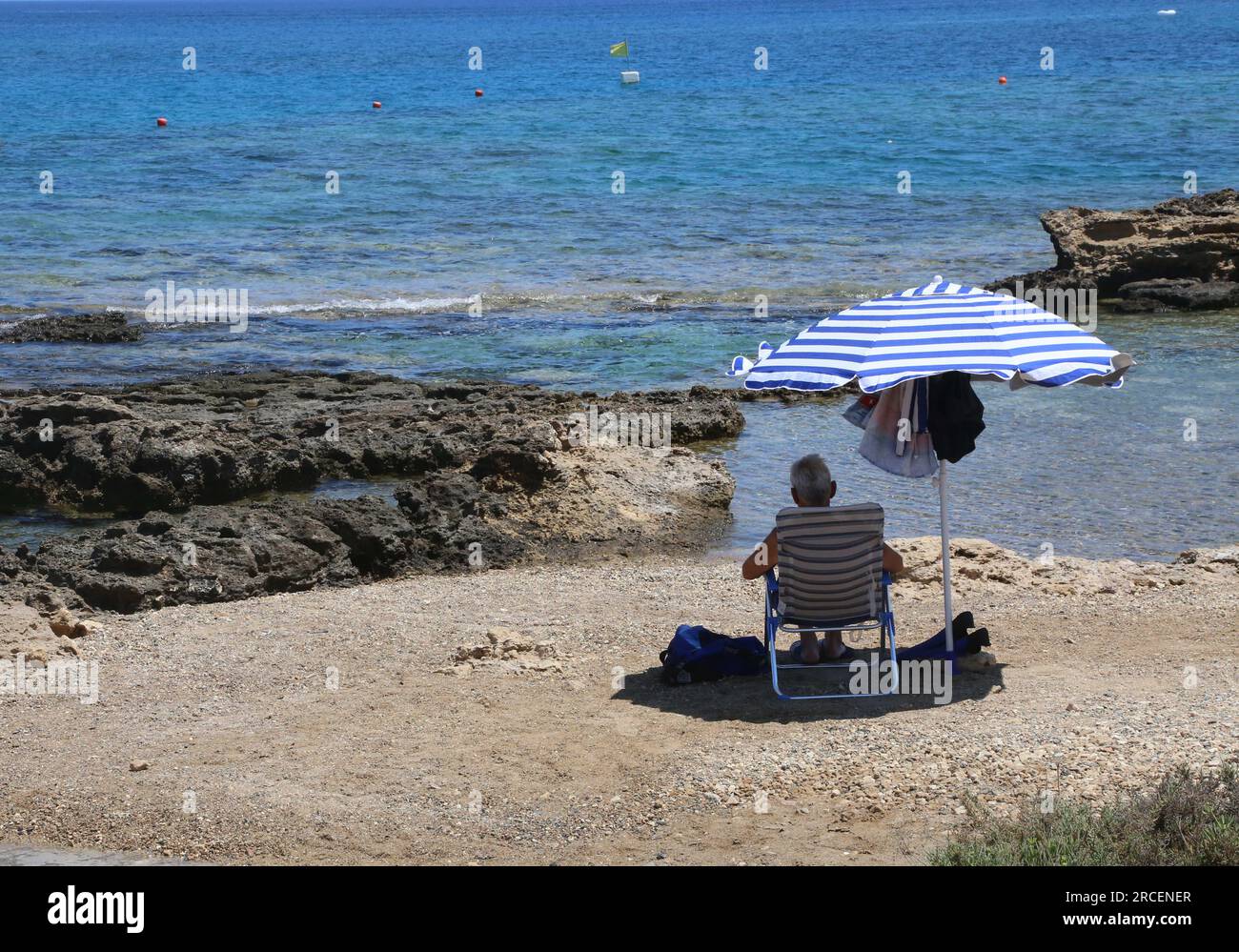 Nicosia, Cyprus. 14th July, 2023. A man rests under an umbrella on a ...