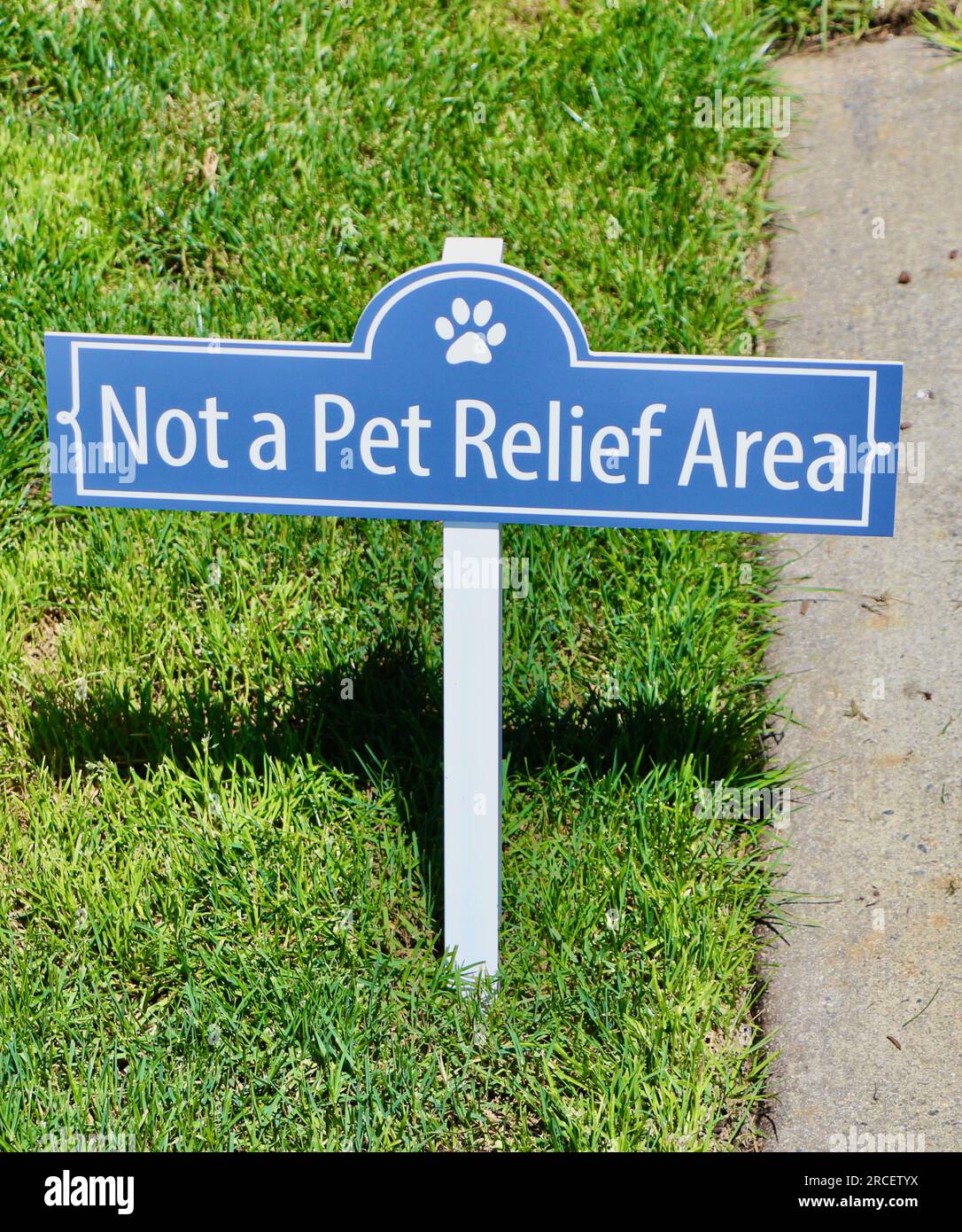 Blue and white sign on a lawn warning Not a Pet Relief Area with a dog ...