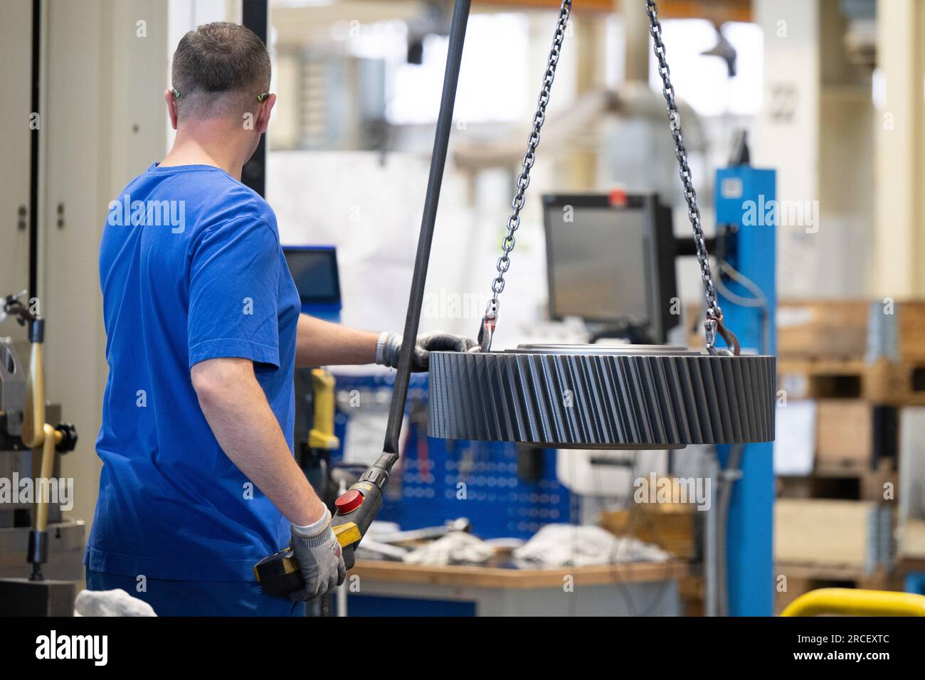 Penig, Germany. 14th July, 2023. An employee works on a gear wheel in a ...
