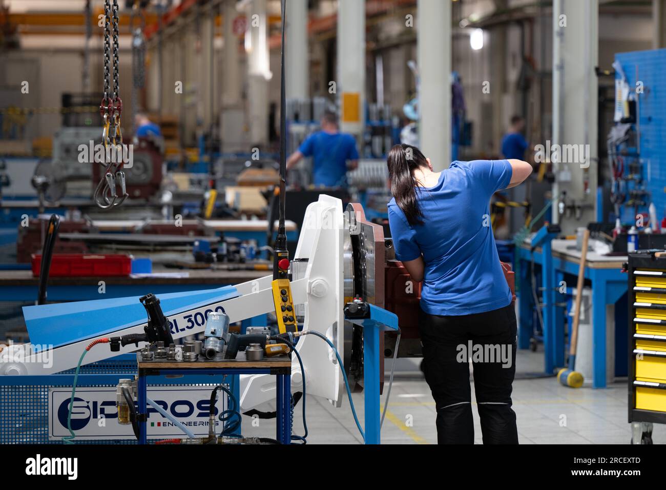 Penig, Germany. 14th July, 2023. A woman stands at a workbench in a ...