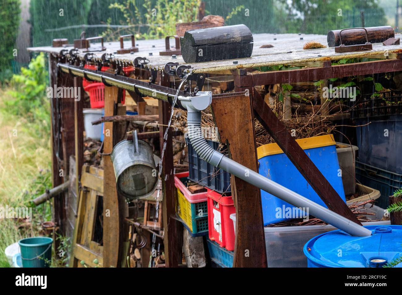 Heavy rain on a garden shed and rainwater harvesting to prevent the ...