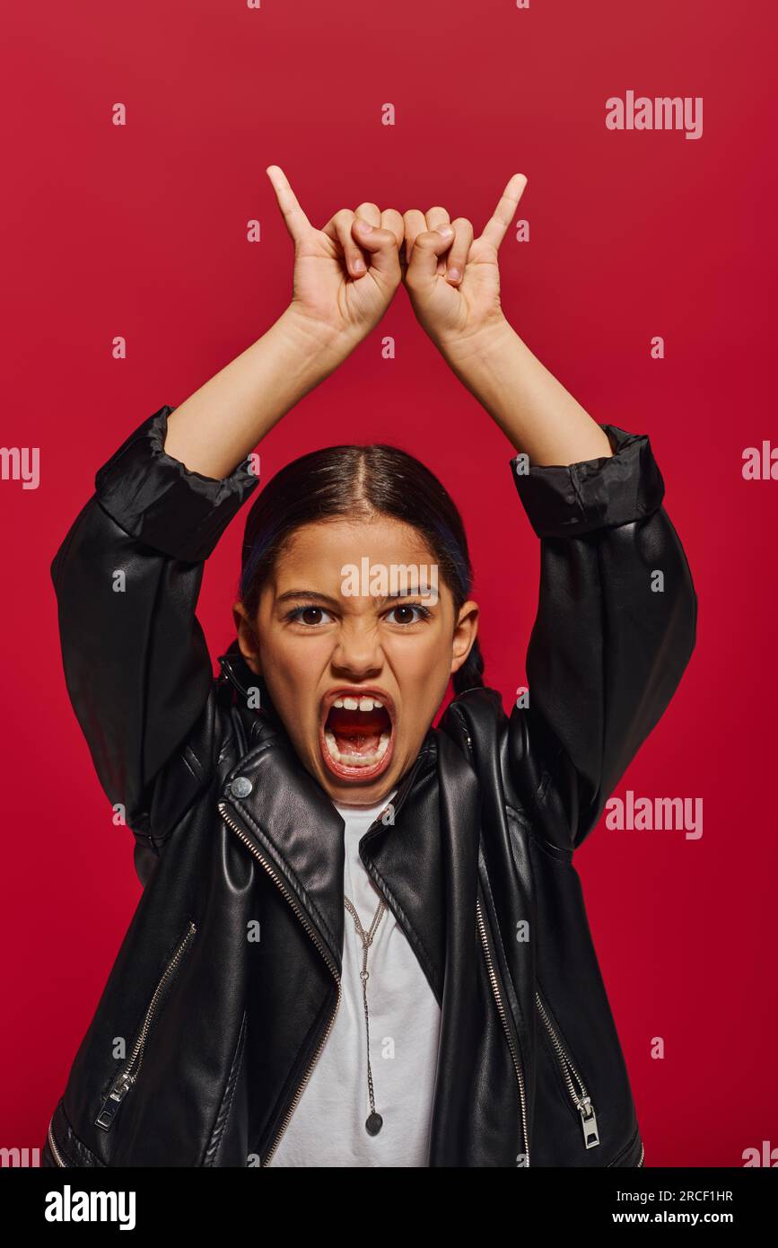 Portrait of mad and fashionable preadolescent girl in leather jacket ...