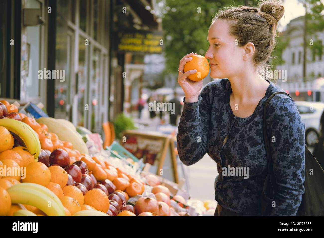 Side view of happy female young-adult taking fruit with her hand ...