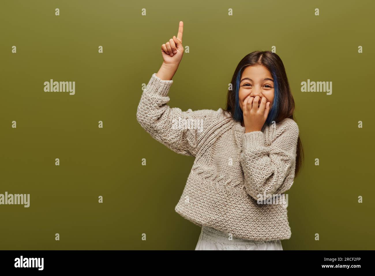 Laughing and stylish preteen girl with dyed hair wearing knitted ...