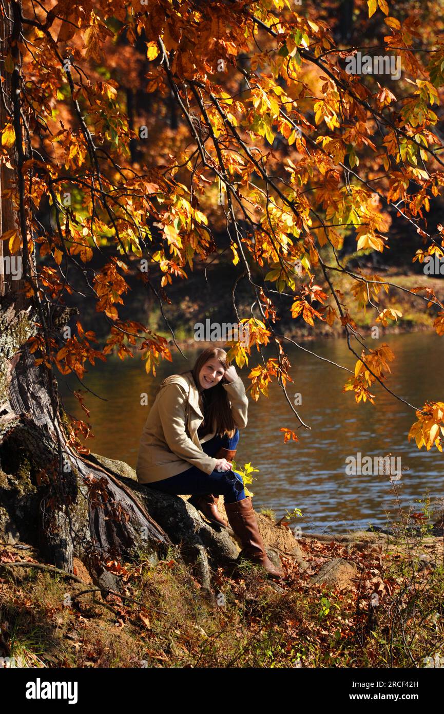 Beautiful young woman leans her head on her hand as she relaxes sitting ...