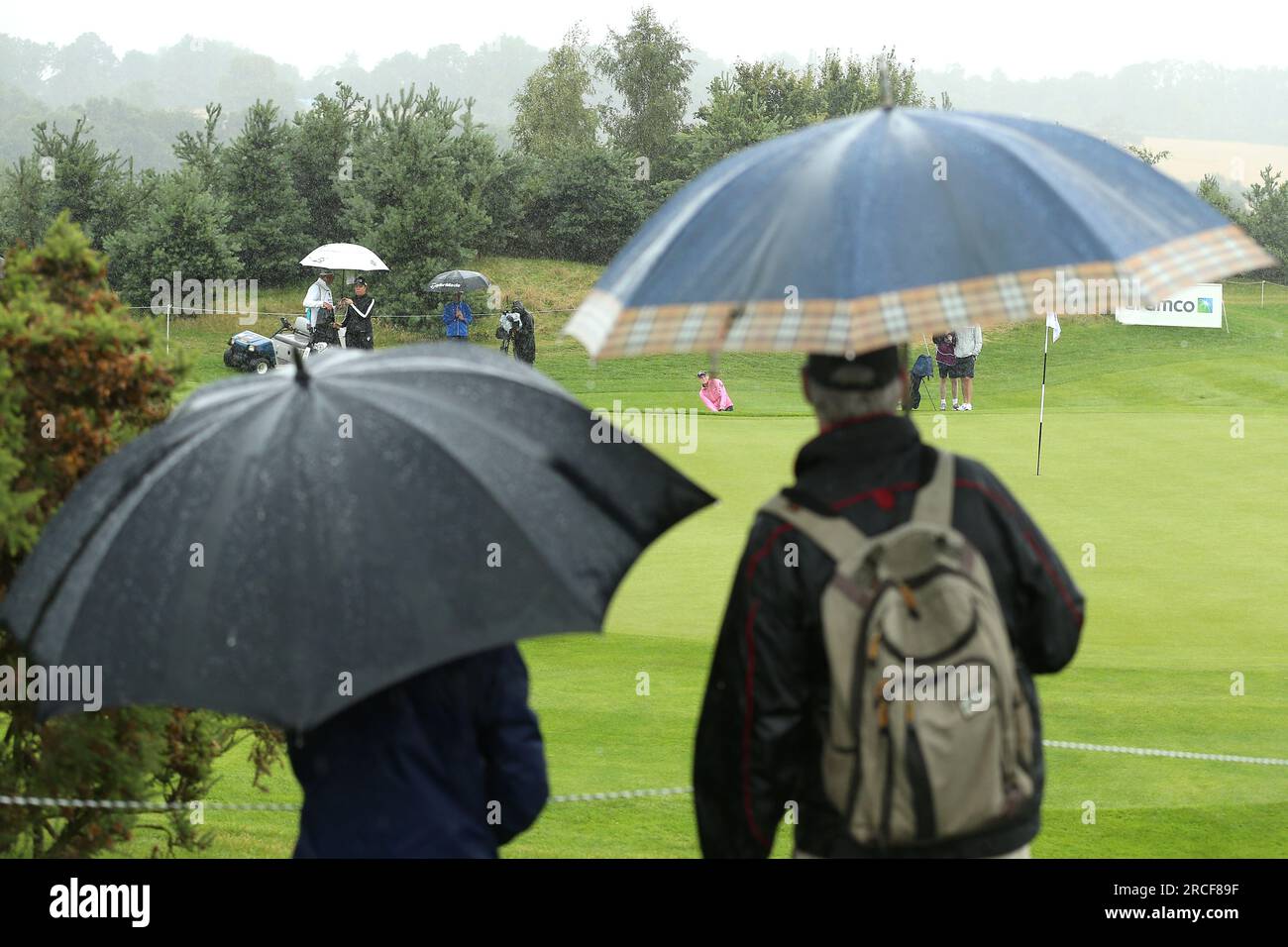Spectators shield themselves from the rain on day one of the 2023 ...