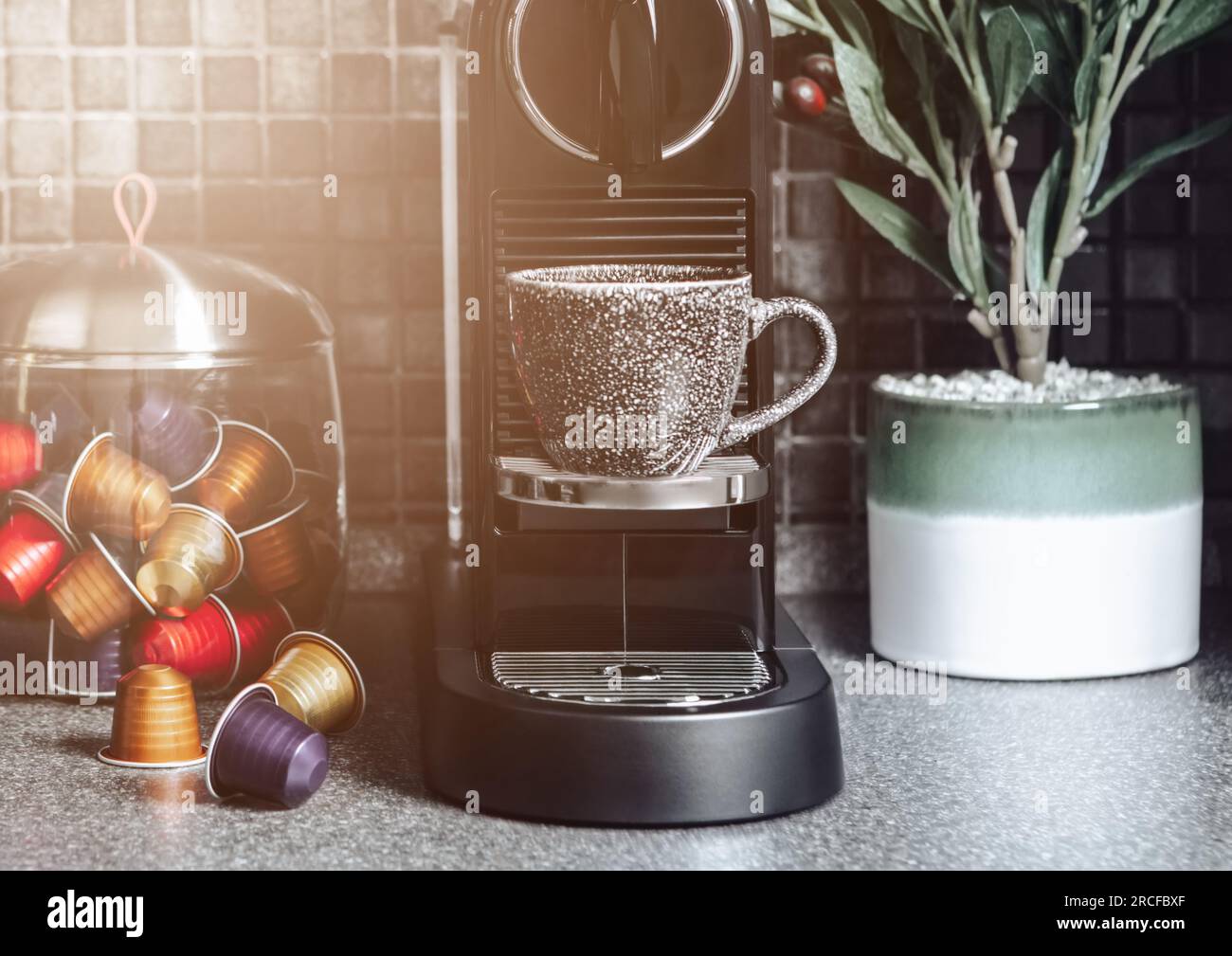 Black coffee cup and home espresso machine with coffee capsules on ...
