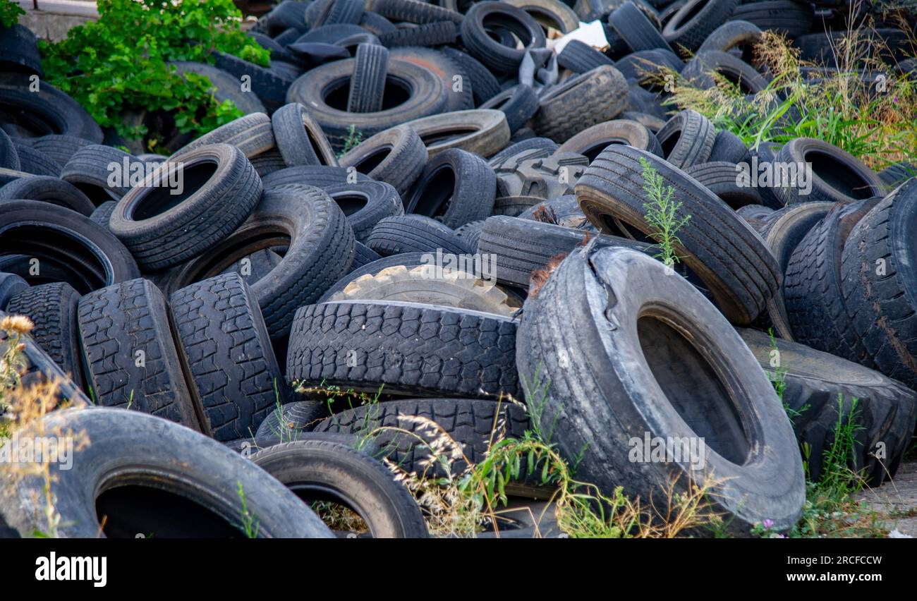 Used tyres on a field among plants in Greece Stock Photo - Alamy