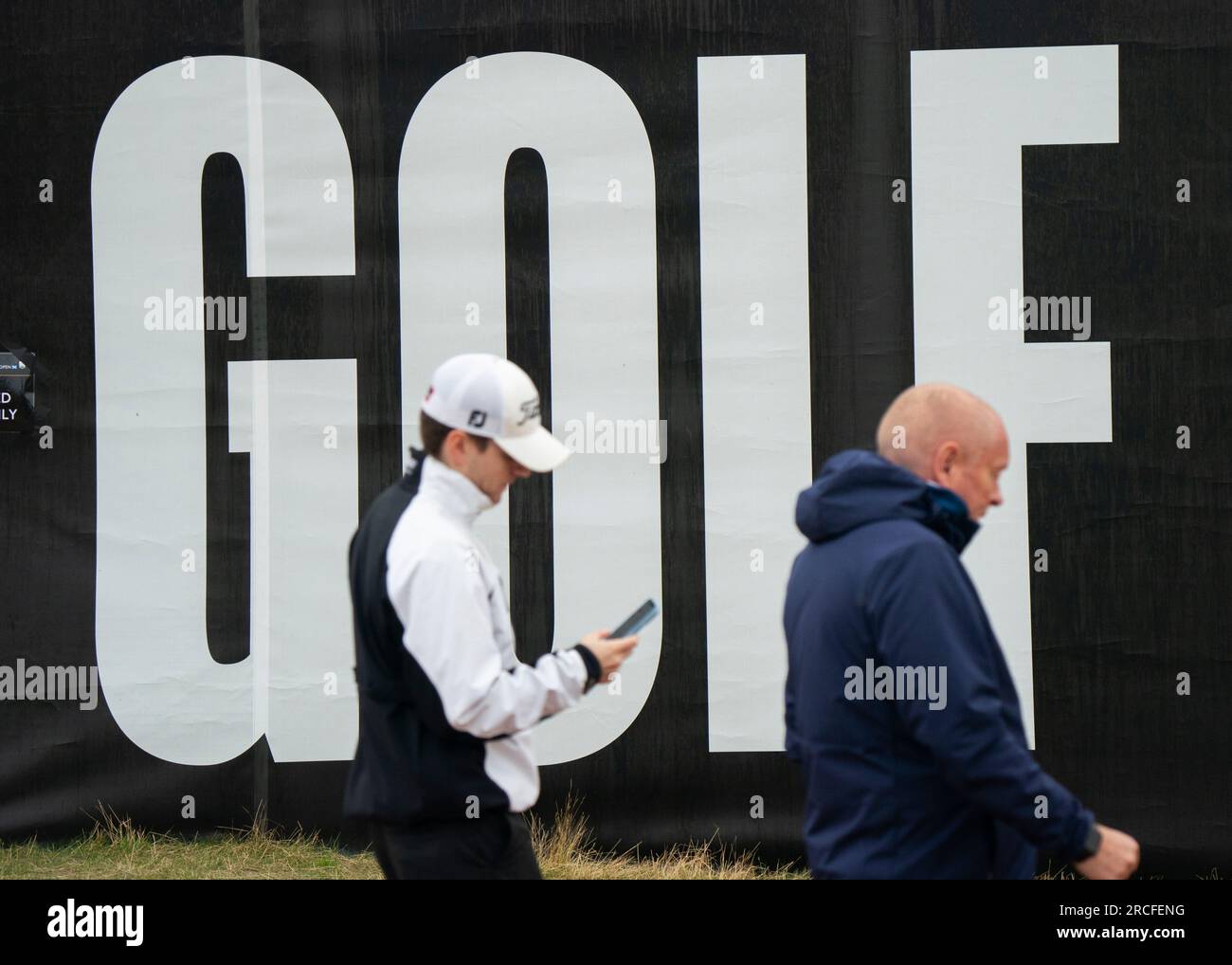 North Berwick, East Lothian, Scotland, UK. 14th July 2023. Spectators walk past a billboard at ...