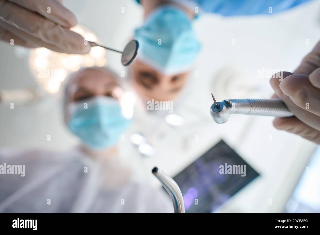 Surgeon dentist with assistant at the workplace in operating room Stock ...