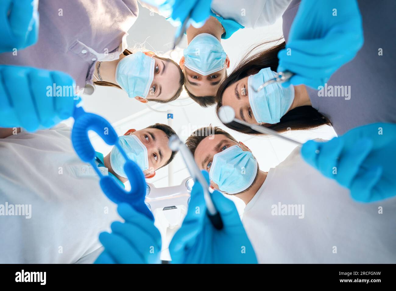 Five doctors, men and women, with dental instruments in their hands ...
