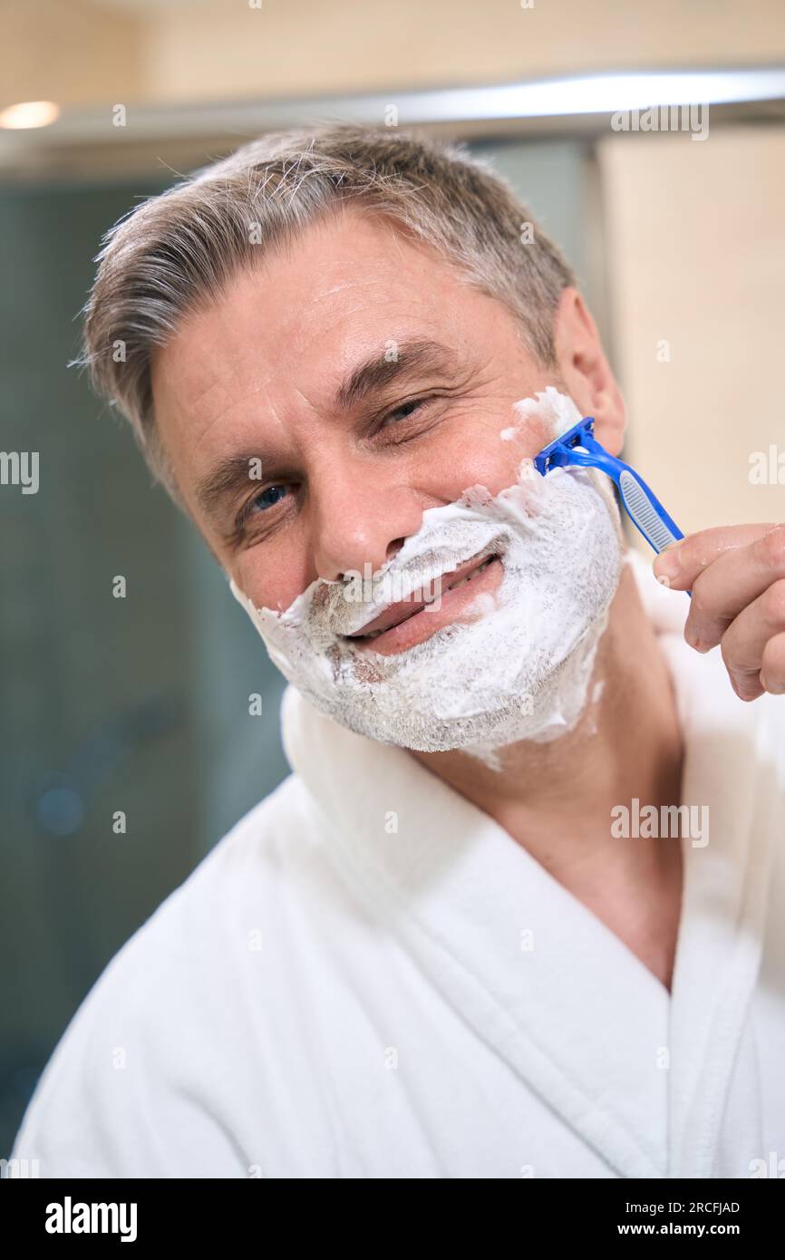 Adult man using razor in the hotel Stock Photo - Alamy