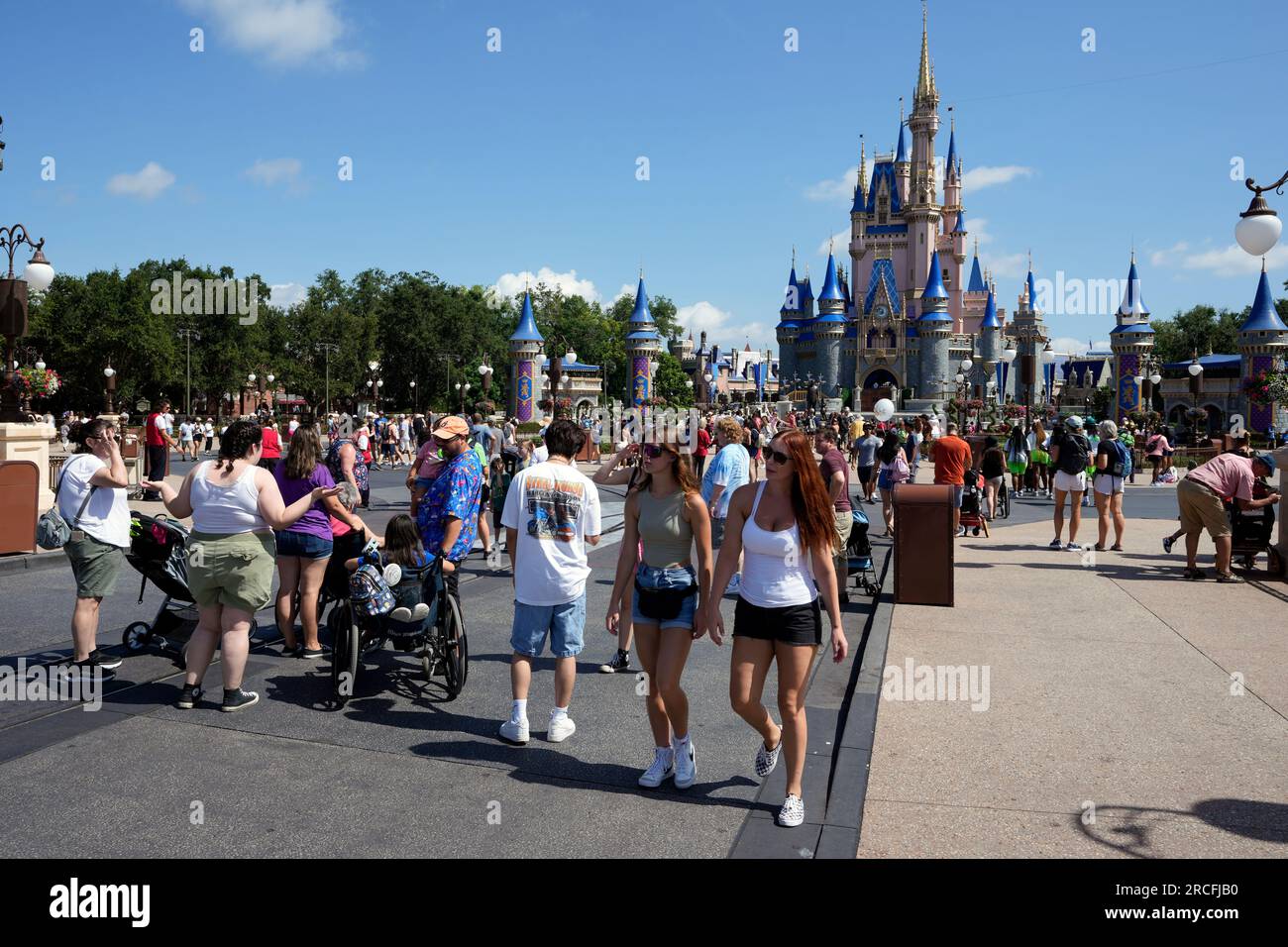 Guests stroll down Main Street in front of the Cinderella Castle at the ...
