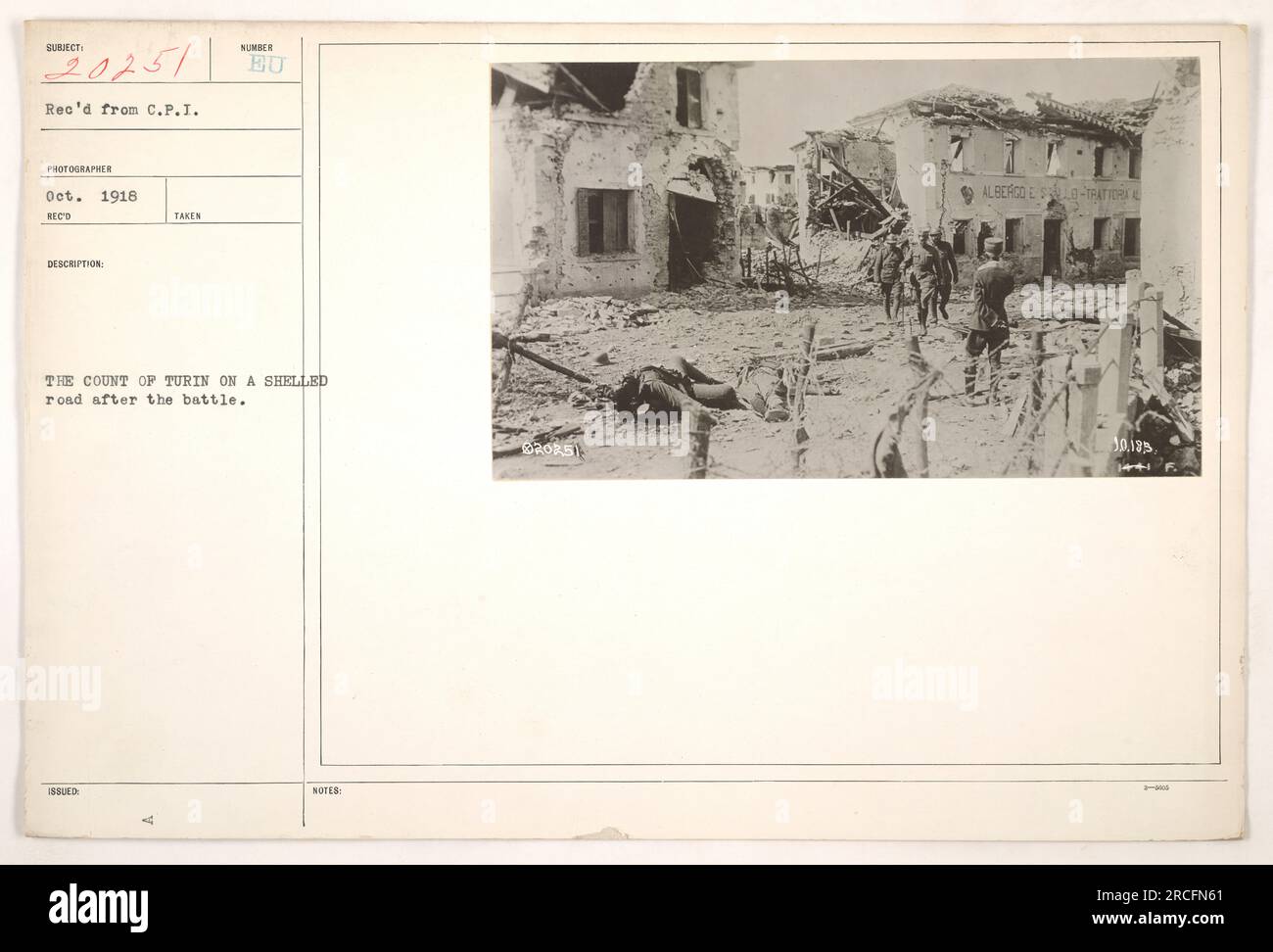 The photograph shows a shelled road in the aftermath of a battle ...