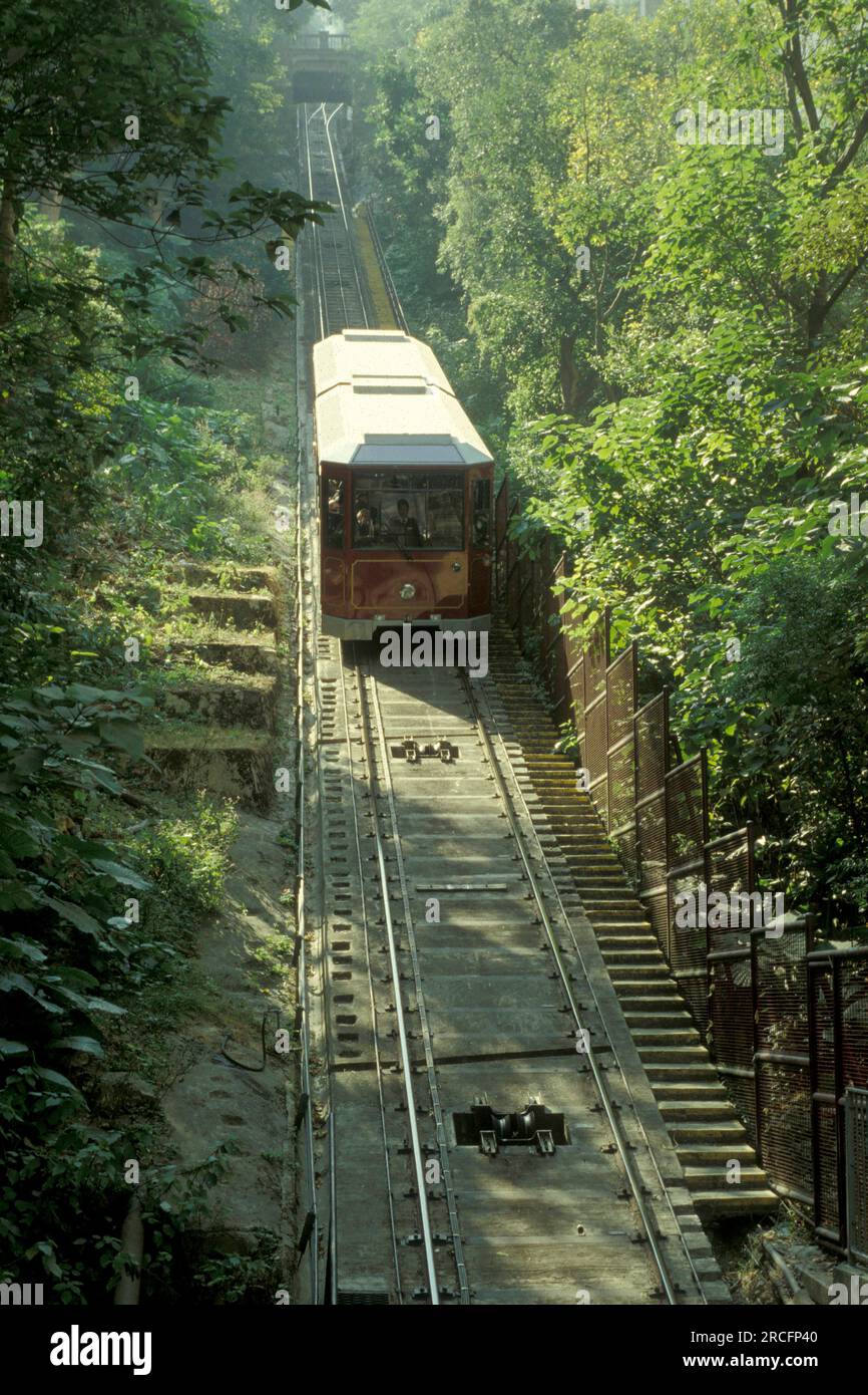 a tram on the way to the Peak Tram Station with a view of the Victoria ...