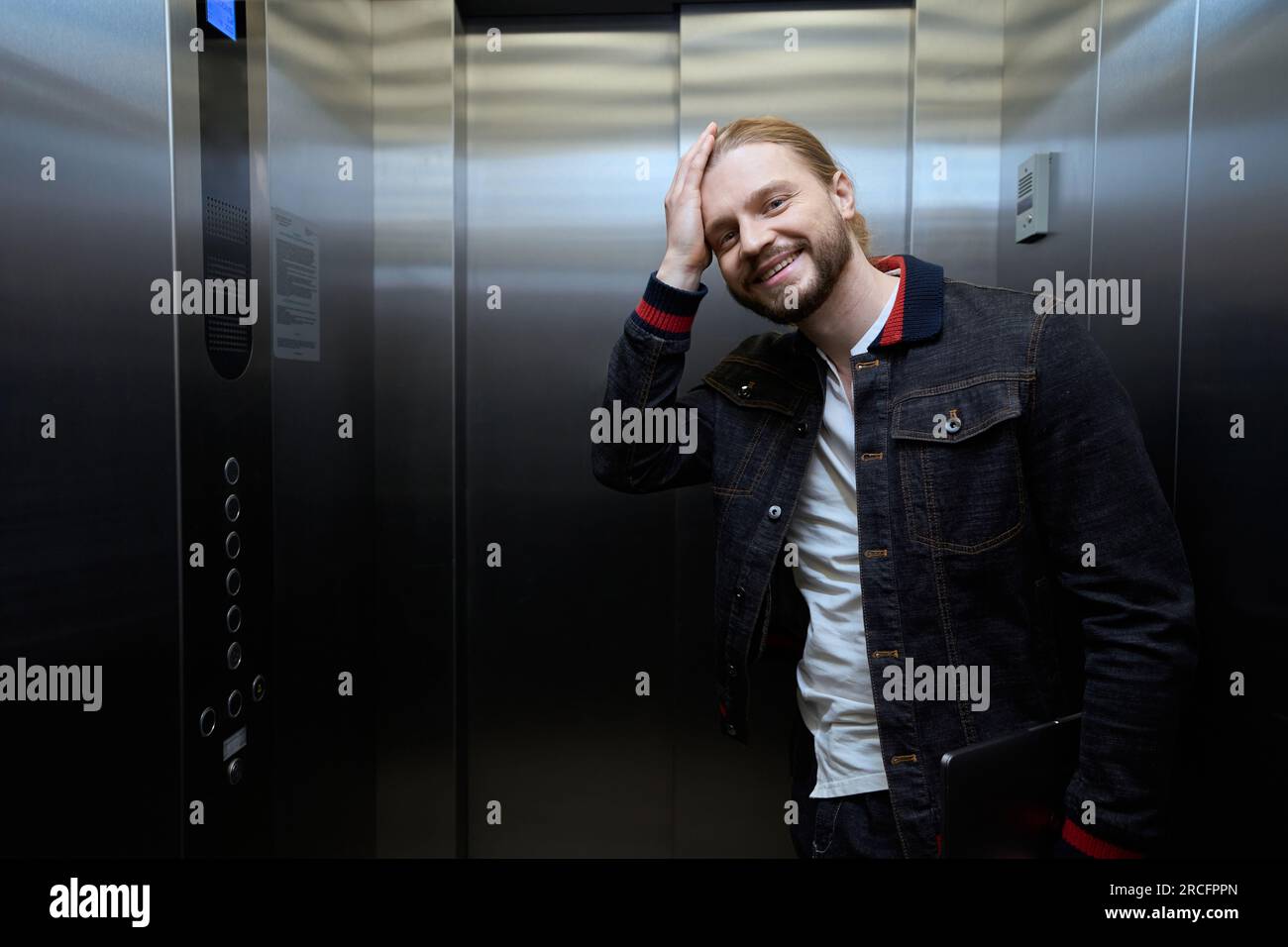 Guy in a denim jacket is in the passenger elevator Stock Photo - Alamy