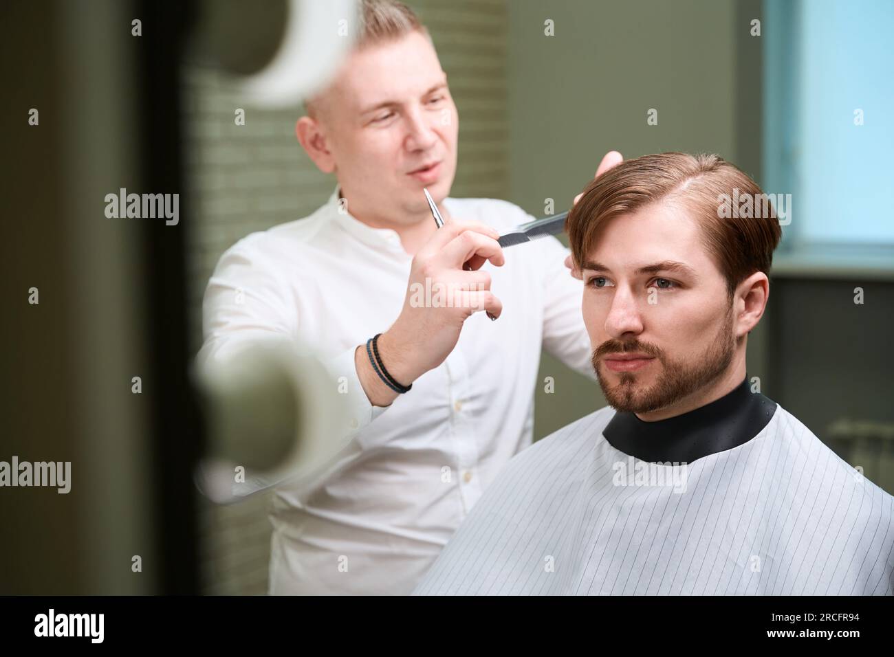 Handsome barber doing his work in modern salon Stock Photo - Alamy