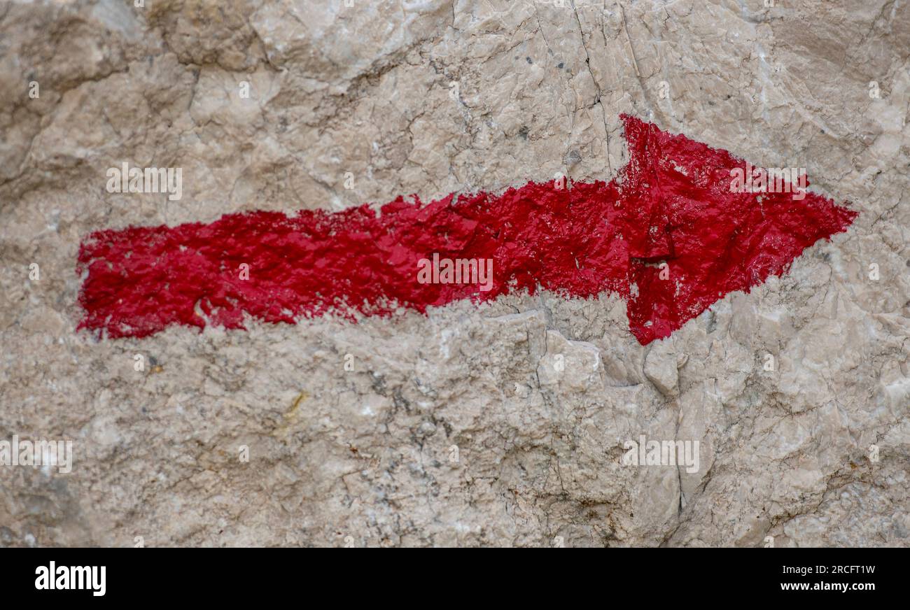 large red arrow painted on a wall indicating the correct direction, red ...