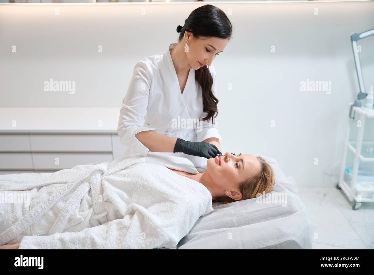 Esthetician makes beauty injections to a beautiful blonde woman Stock ...