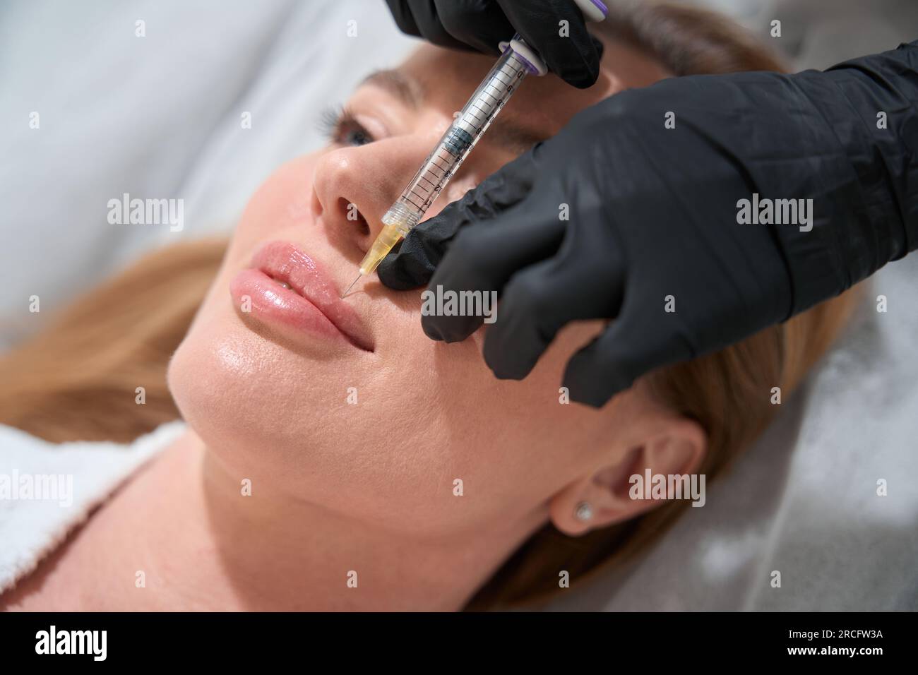 Female client is on a rejuvenating injection procedure Stock Photo - Alamy