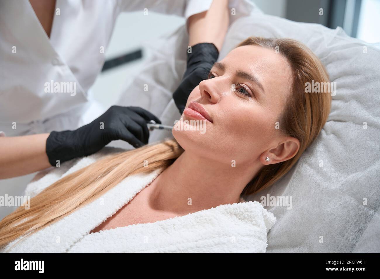 Beautiful female receives a rejuvenating chin injection Stock Photo - Alamy