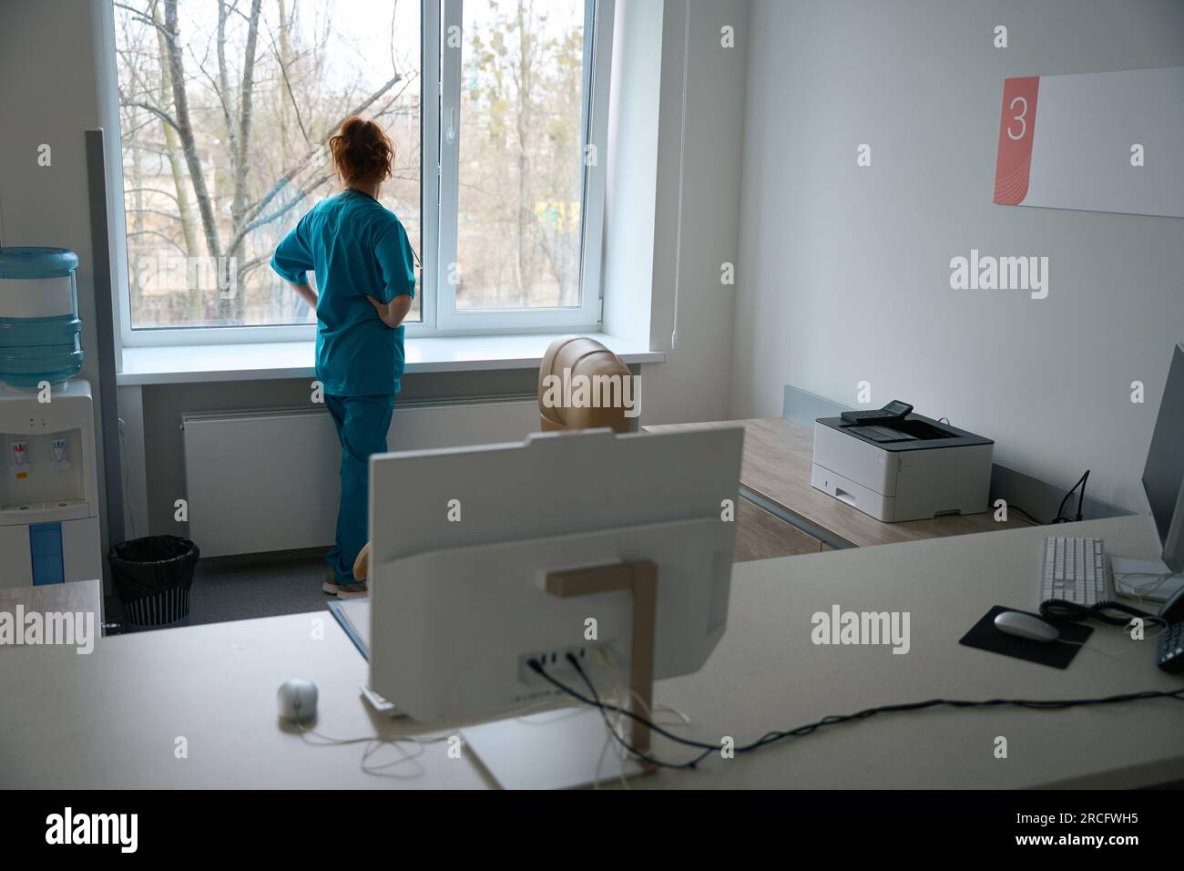 Female doctor looking through window in hospital Stock Photo - Alamy