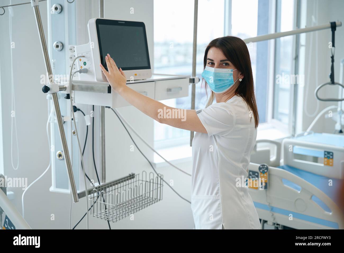 Female doctor control heart rate pulse on the monitor in intensive care ...