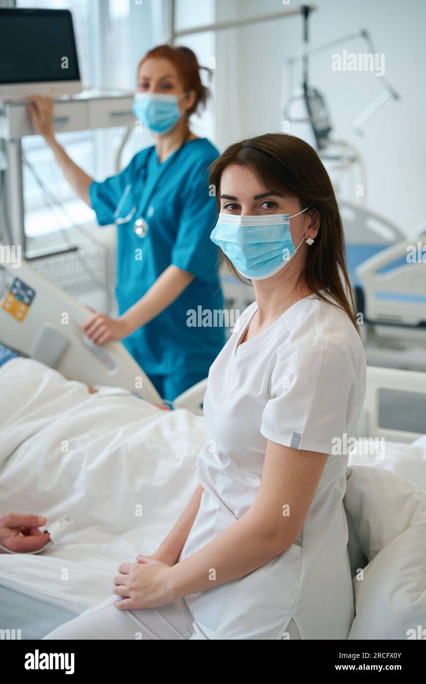 Female medics near patient's bed in hospital Stock Photo - Alamy